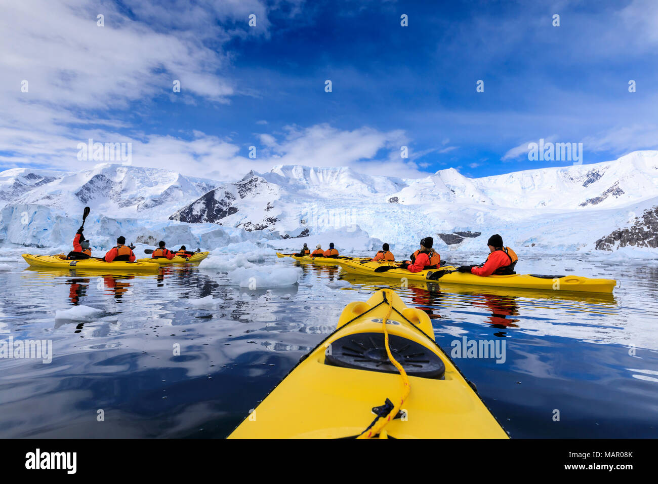 Kayaking amongst spectacular icebergs, mountains and glaciers, sunny ...