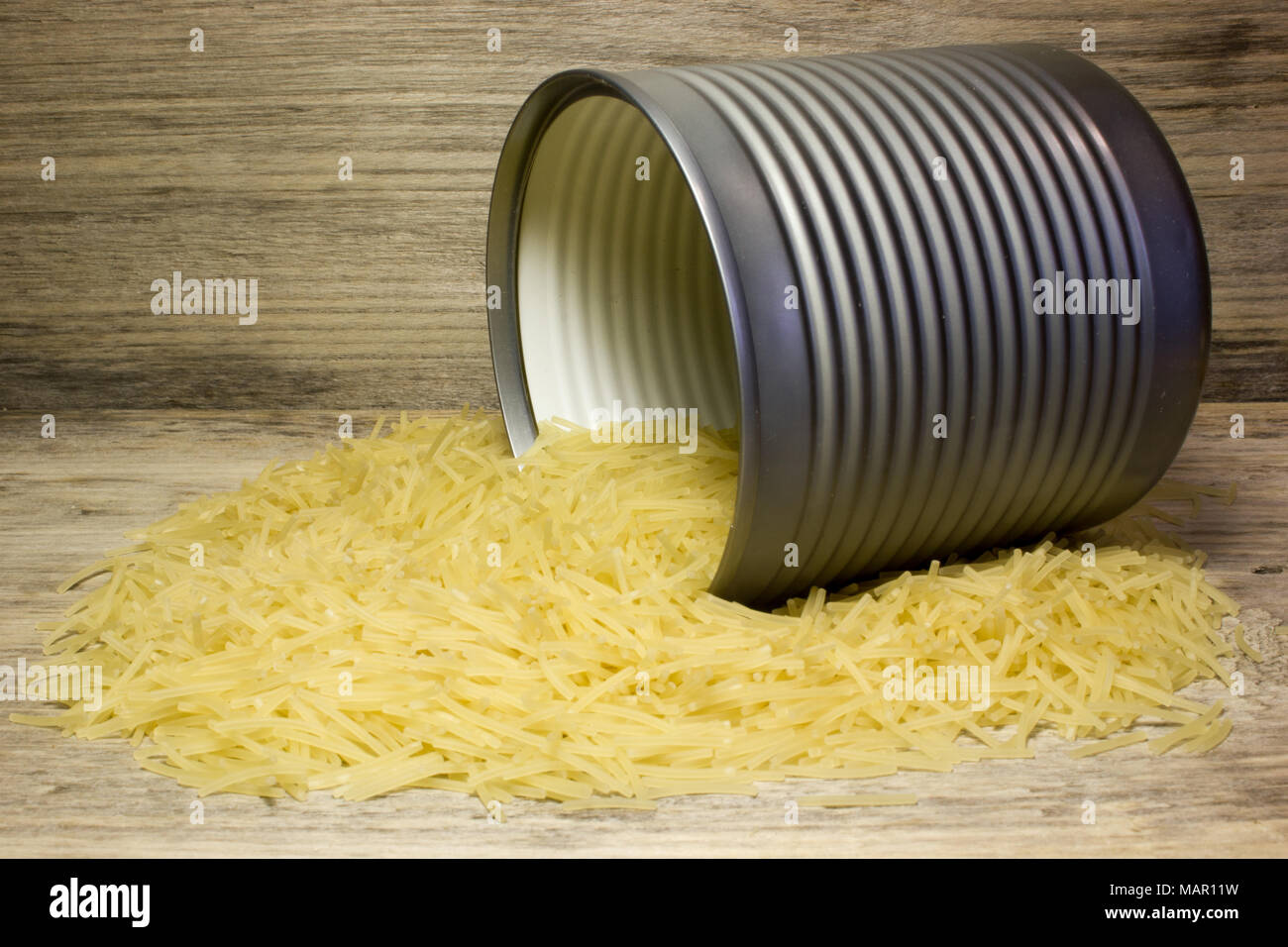 Small dry pasta in tin noodles on wooden background Stock Photo - Alamy