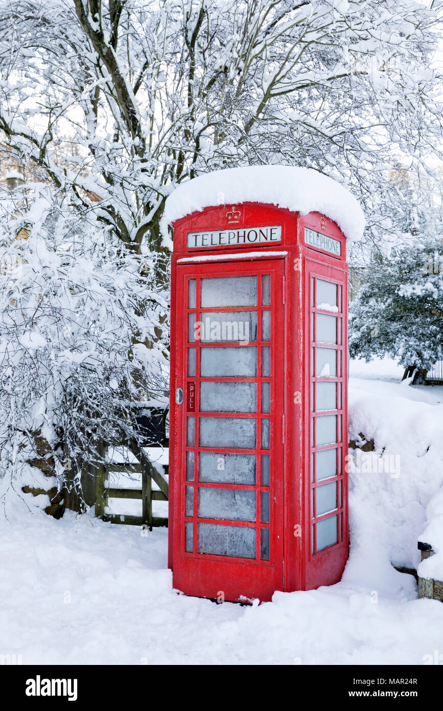 Traditional British red telephone box covered in winter snow, Snowshill ...