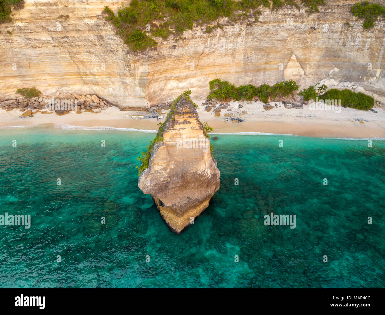 Indonesia. A narrow strip of empty wild beach near the rocky shore ...