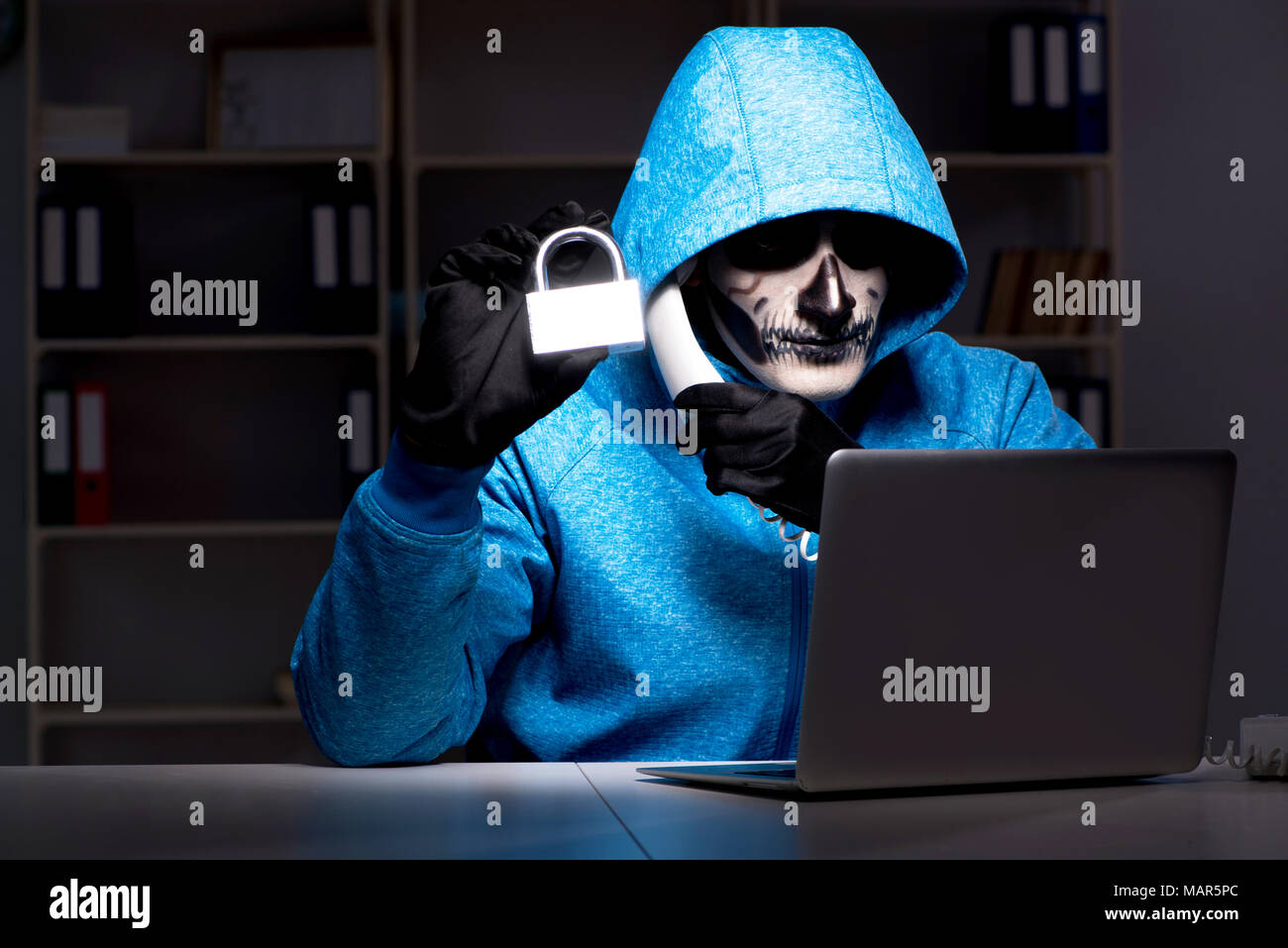 Scary hacker hacking security firewall late in office Stock Photo - Alamy