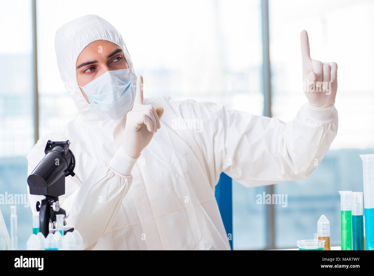 Young chemist pressing virtual buttons in lab Stock Photo - Alamy