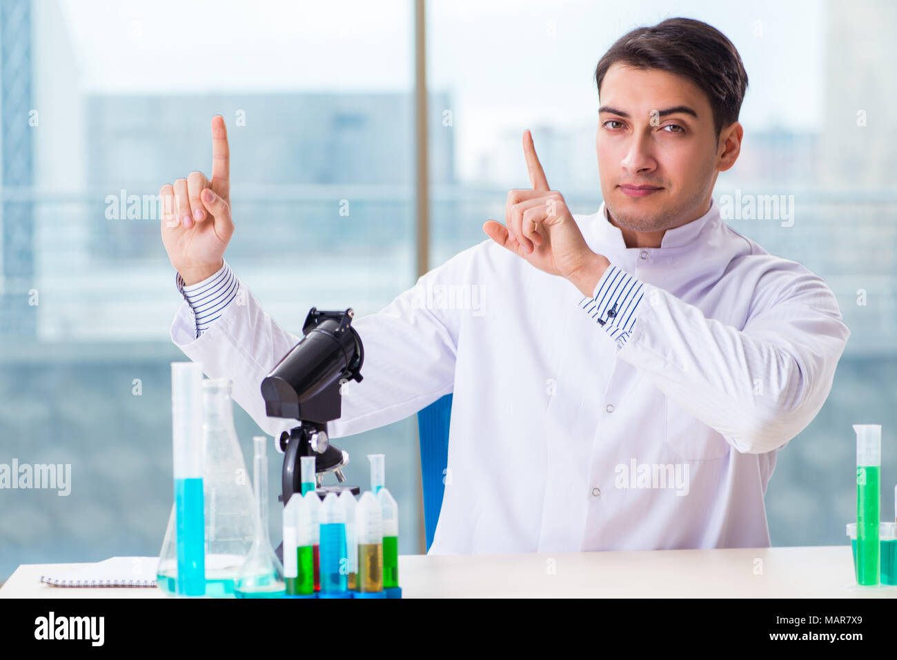 Young chemist pressing virtual buttons in lab Stock Photo - Alamy