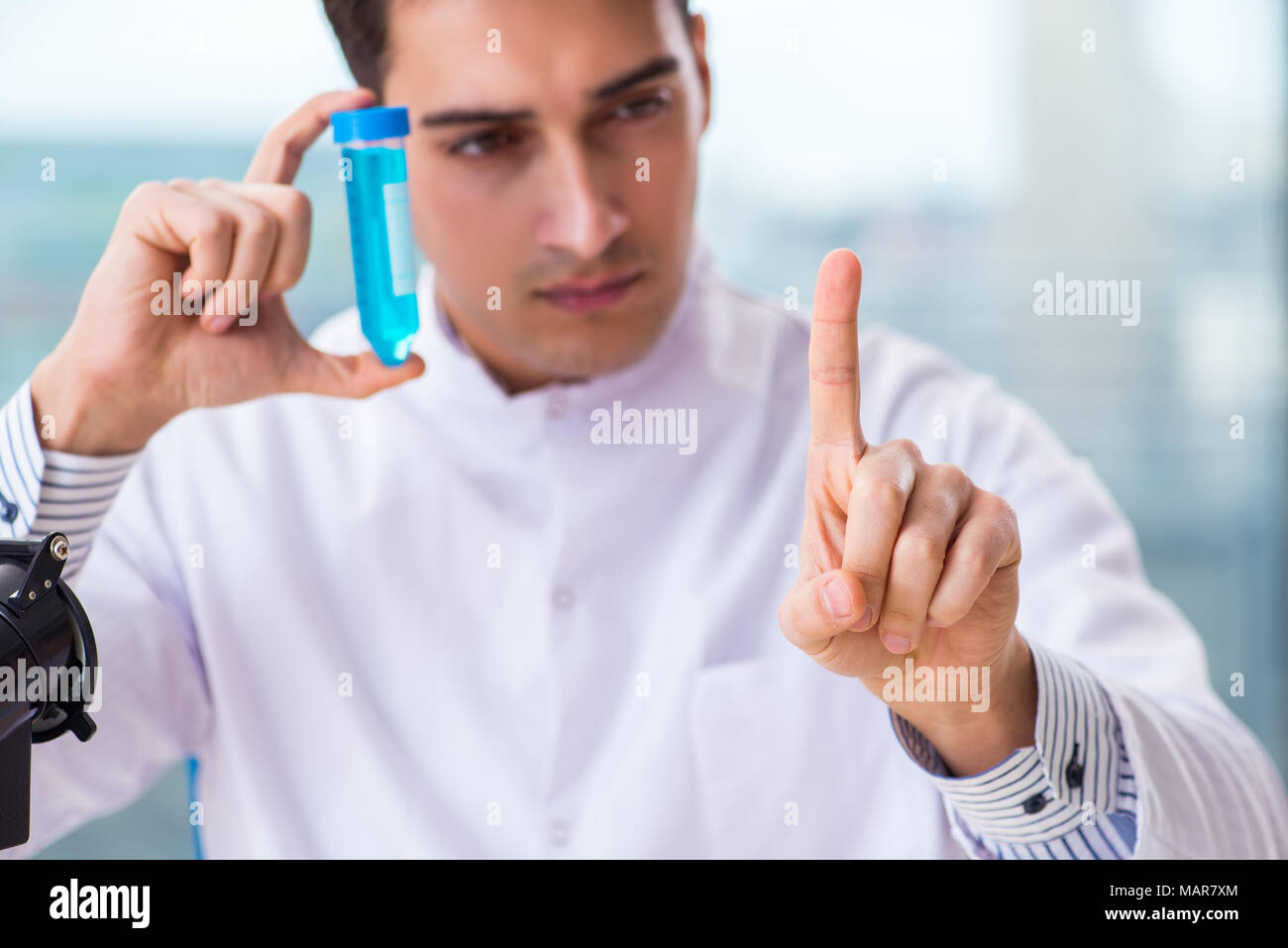 Young chemist pressing virtual buttons in lab Stock Photo - Alamy