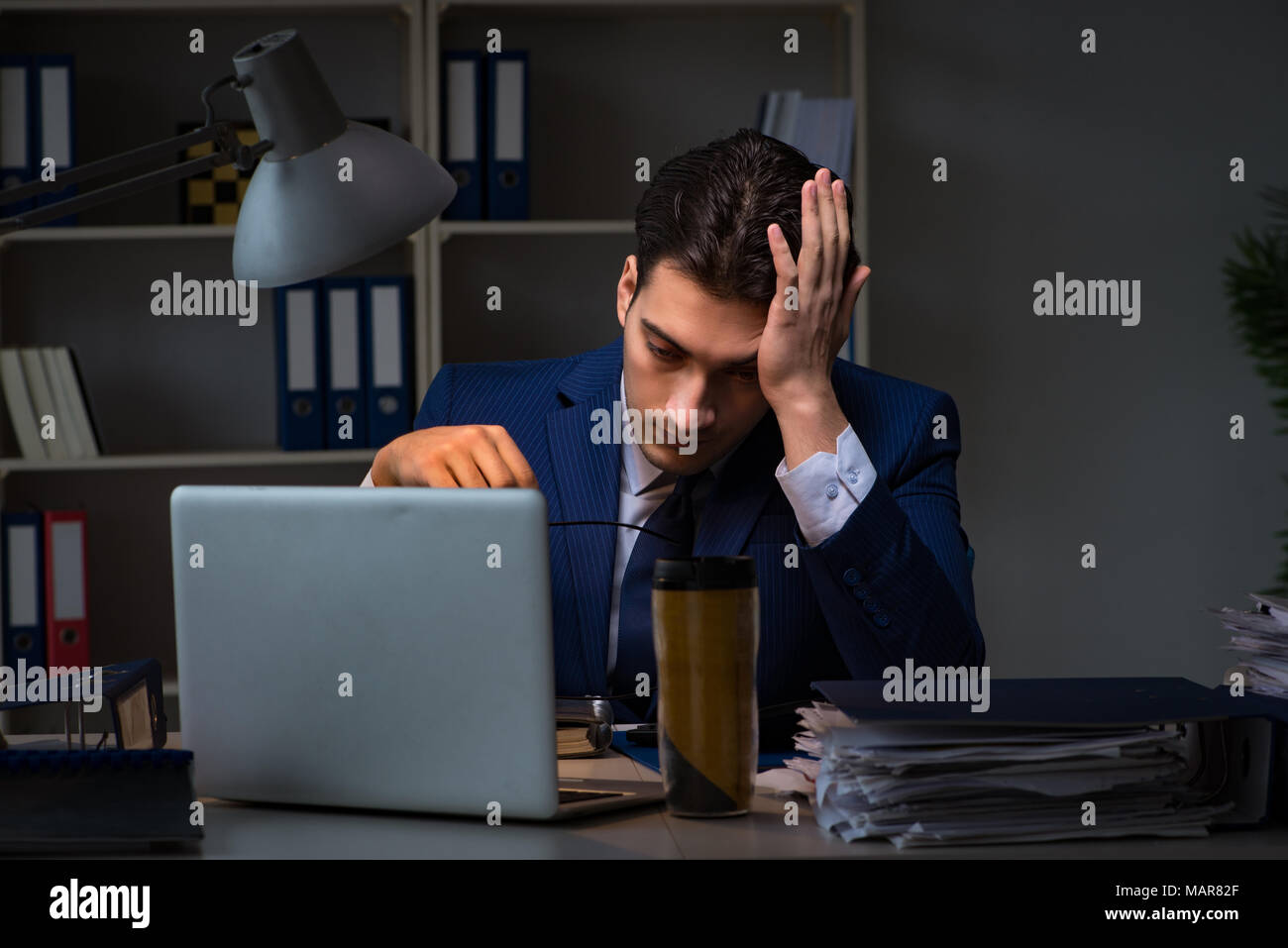 Employee working late to finish important deliverable task Stock Photo ...