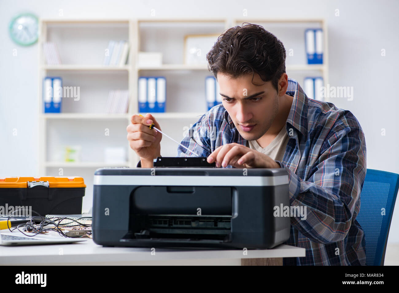 Hardware repairman repairing broken printer fax machine Stock Photo - Alamy