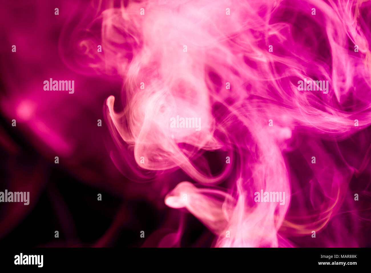 Dense pink and red multicolored smoke on a black isolated background ...