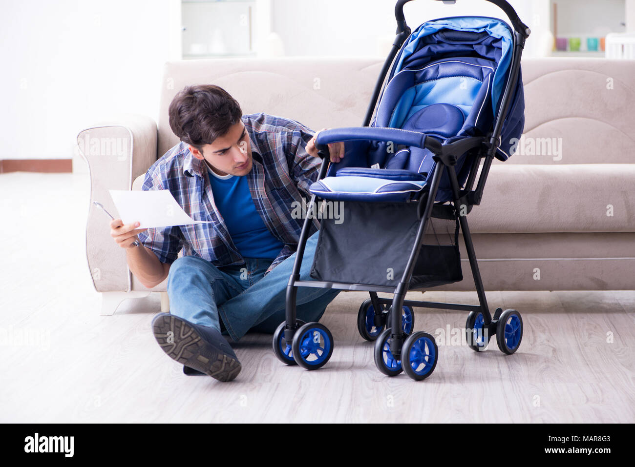 Young father assembling baby pram at home Stock Photo - Alamy