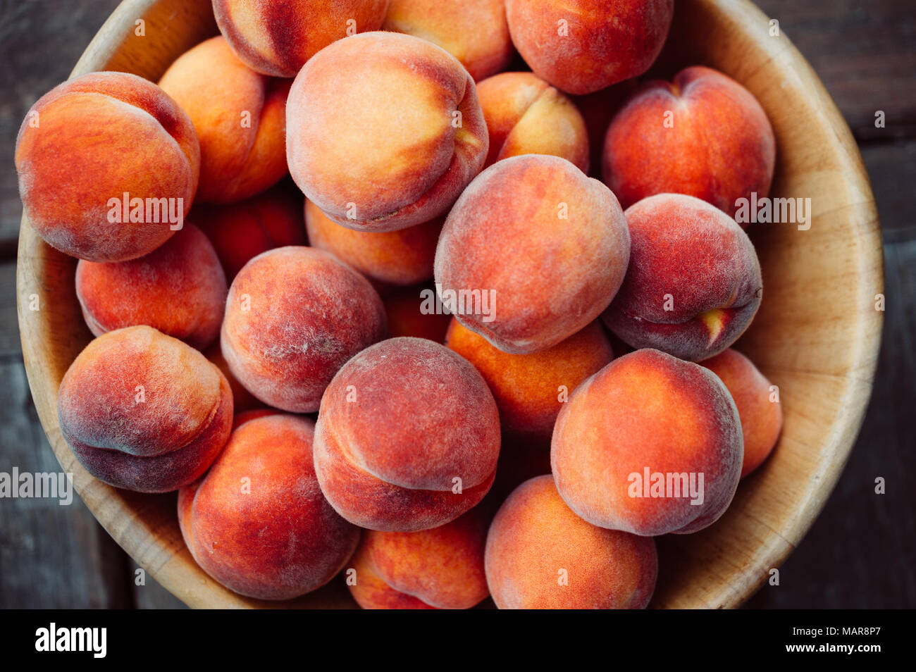 Top down view of a group of ripe peaches in a wooden bowl Stock Photo ...