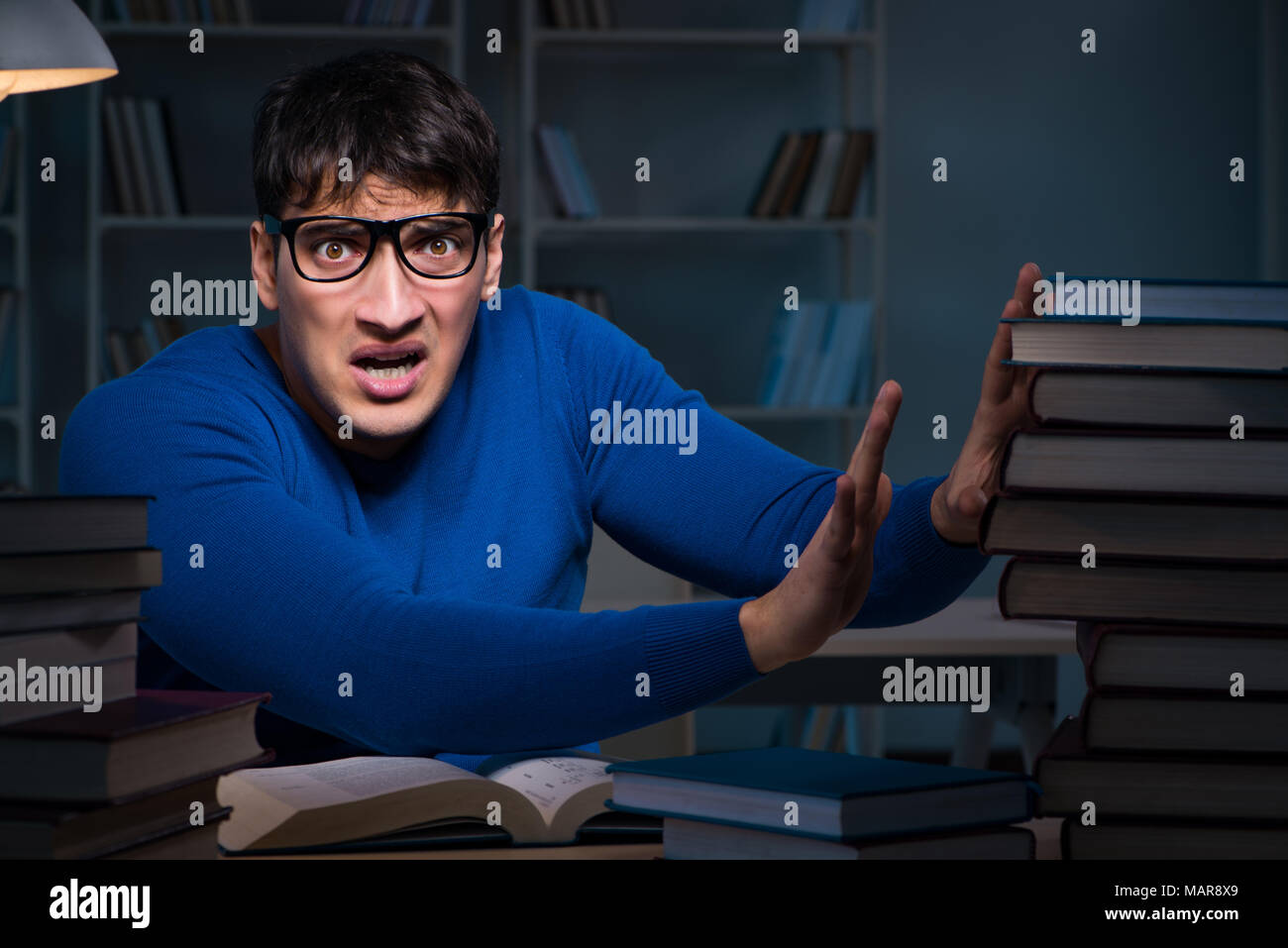 Student preparing for exams late at night in library Stock Photo - Alamy