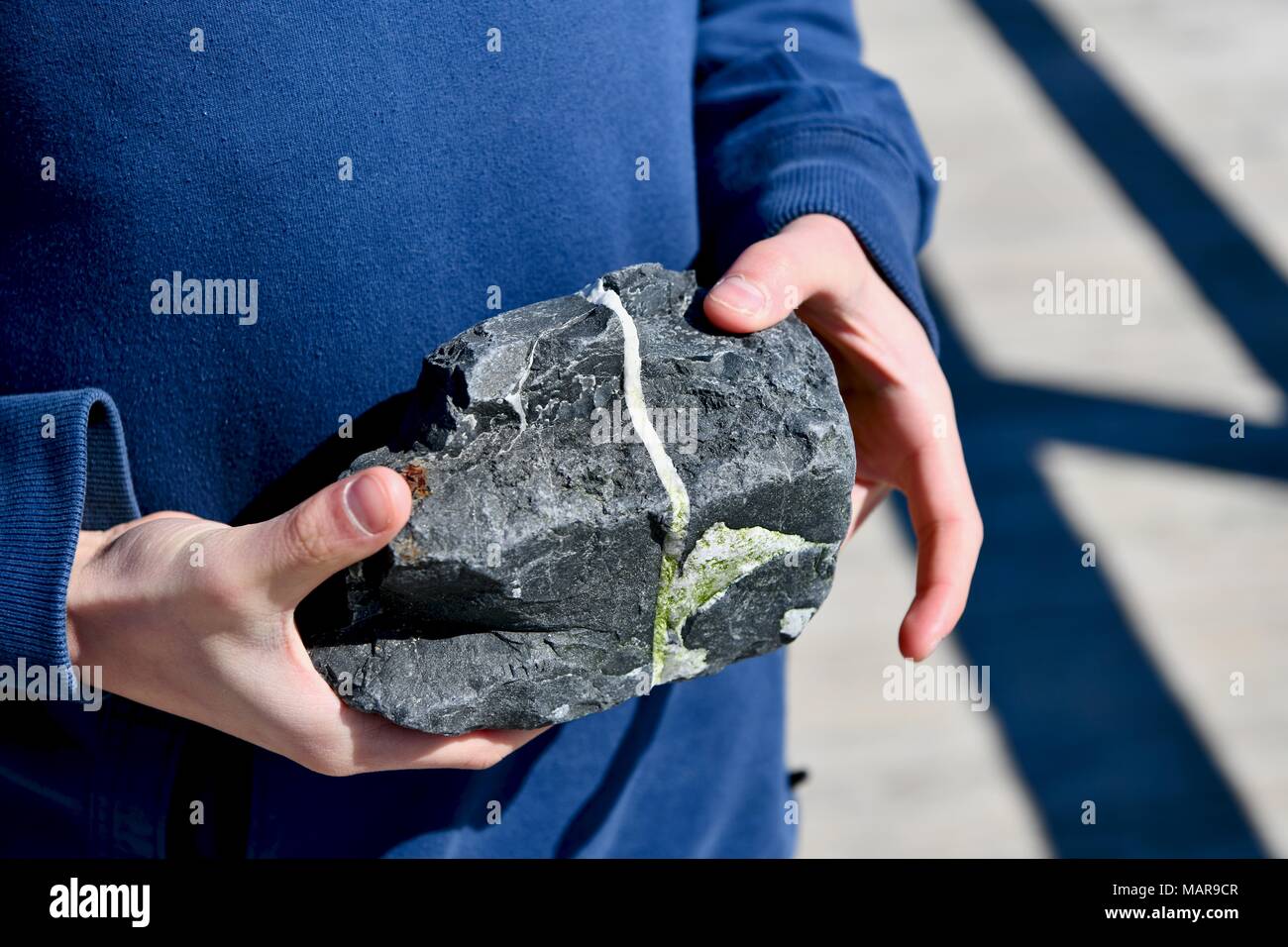 Holding a rock in hands Stock Photo - Alamy