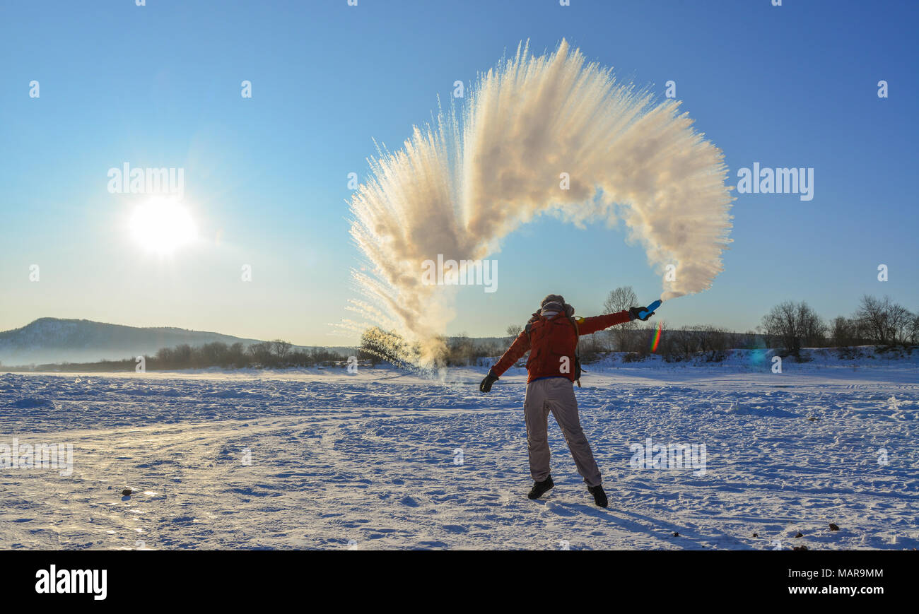 A tourist throwing hot water on ice river in Mohe County, Heilongjiang ...