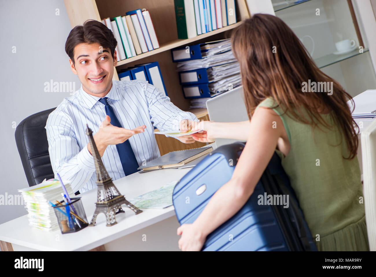 Customer visiting travel agency and talking to agent Stock Photo - Alamy