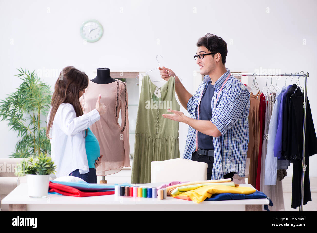 Pregnant woman visiting tailor for new clothing Stock Photo - Alamy