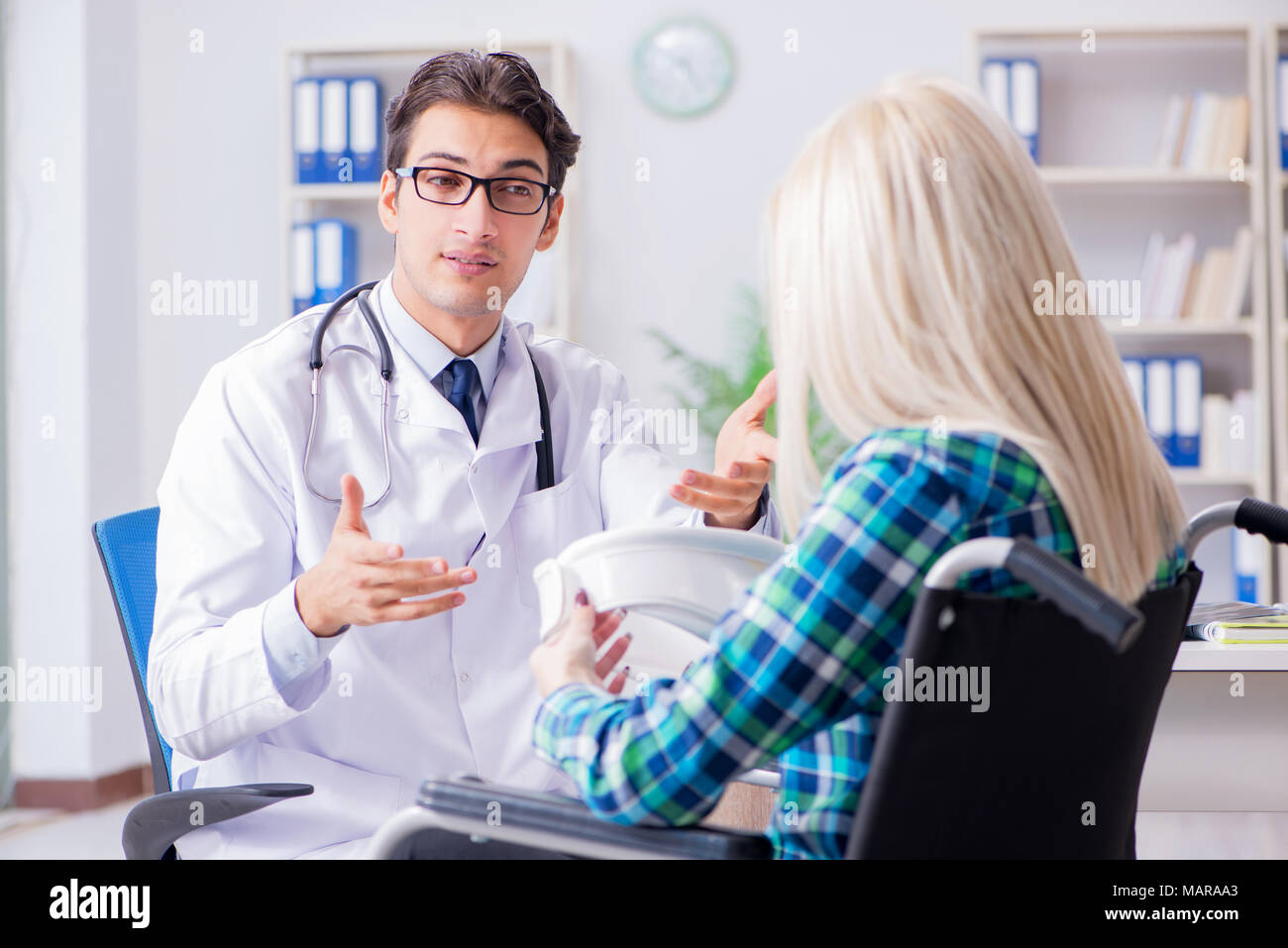 Disabled woman in wheel chair visiting man doctor Stock Photo - Alamy