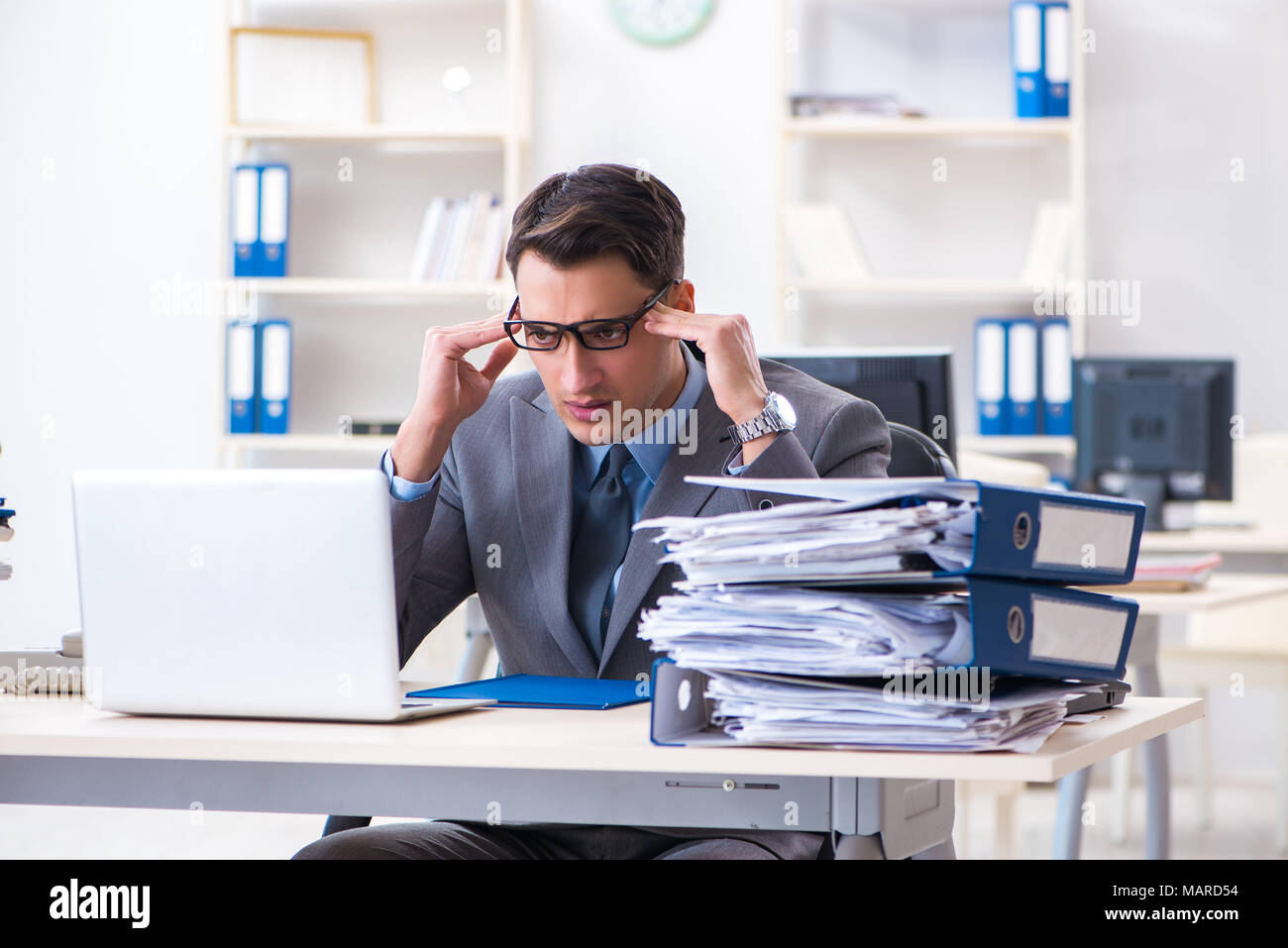 Overloaded with work employee under paperwork burden Stock Photo - Alamy