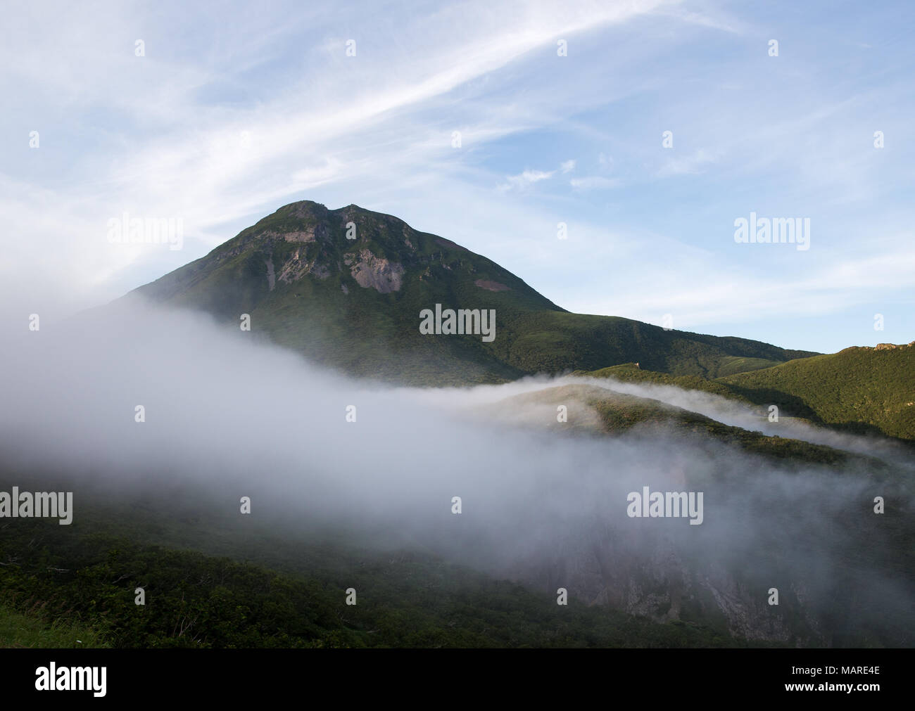 Fog rolls over Mt. Rausu late in the day Stock Photo - Alamy