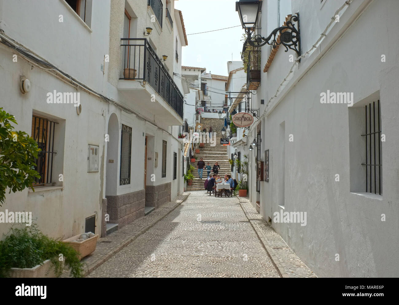 a typical white painted village street scene in Altea, Alicante, Spain ...