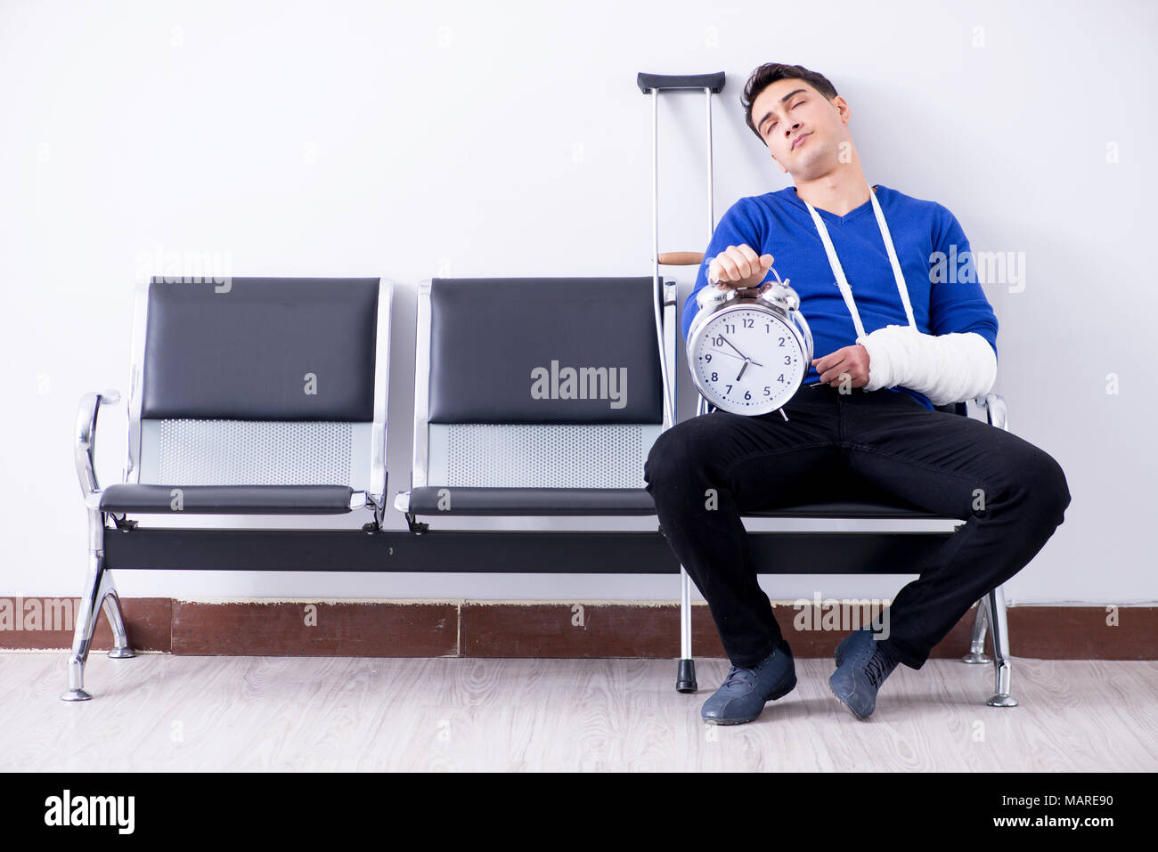 Desperate man waiting for his appointment in hospital with broken arm ...
