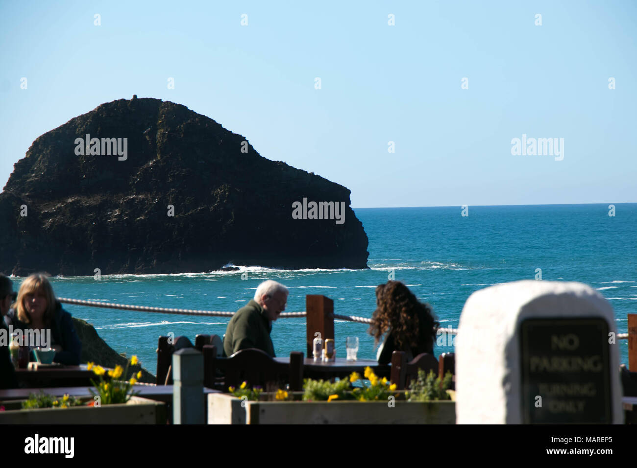 Tourists enjoying lunch at a pub with a sea ocean view at Trebarwith ...