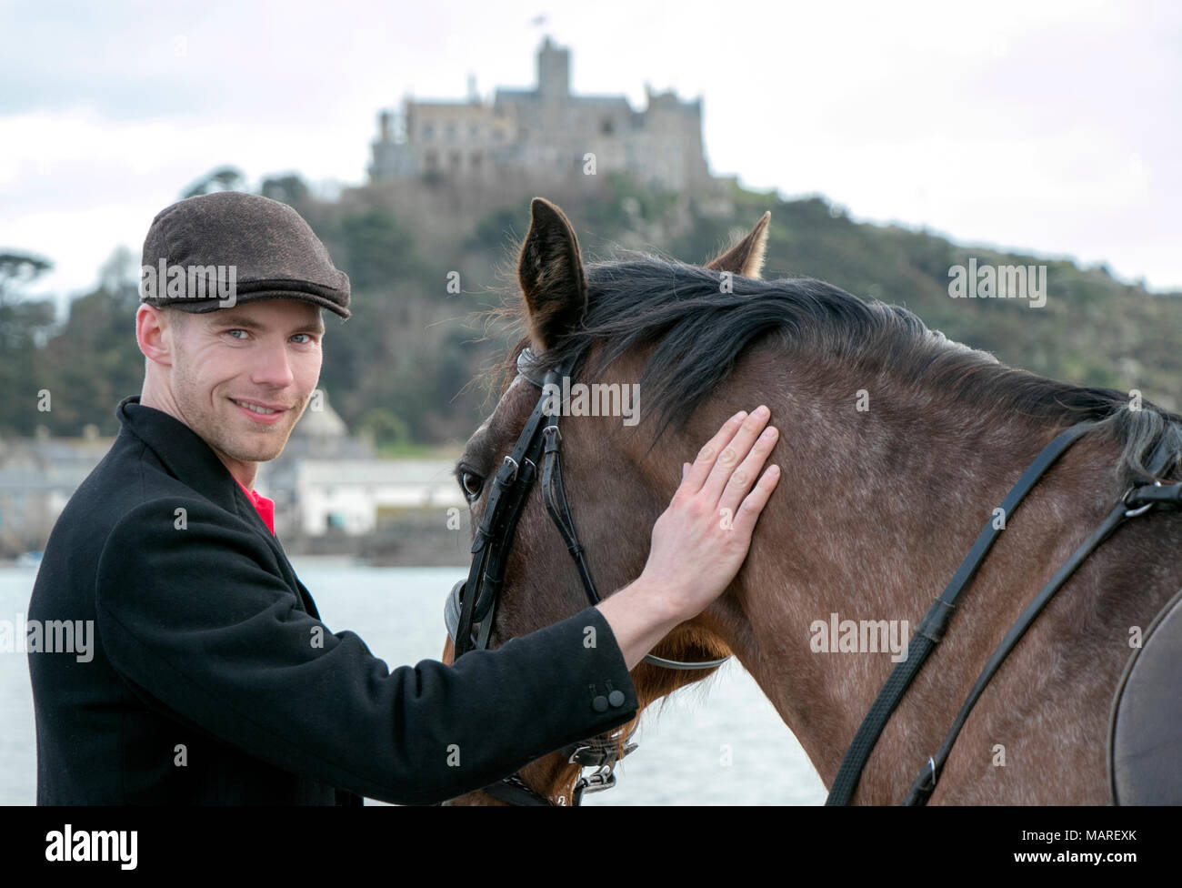 Handsome Male Horse Rider standing walking his horse, wearing flat cap ...