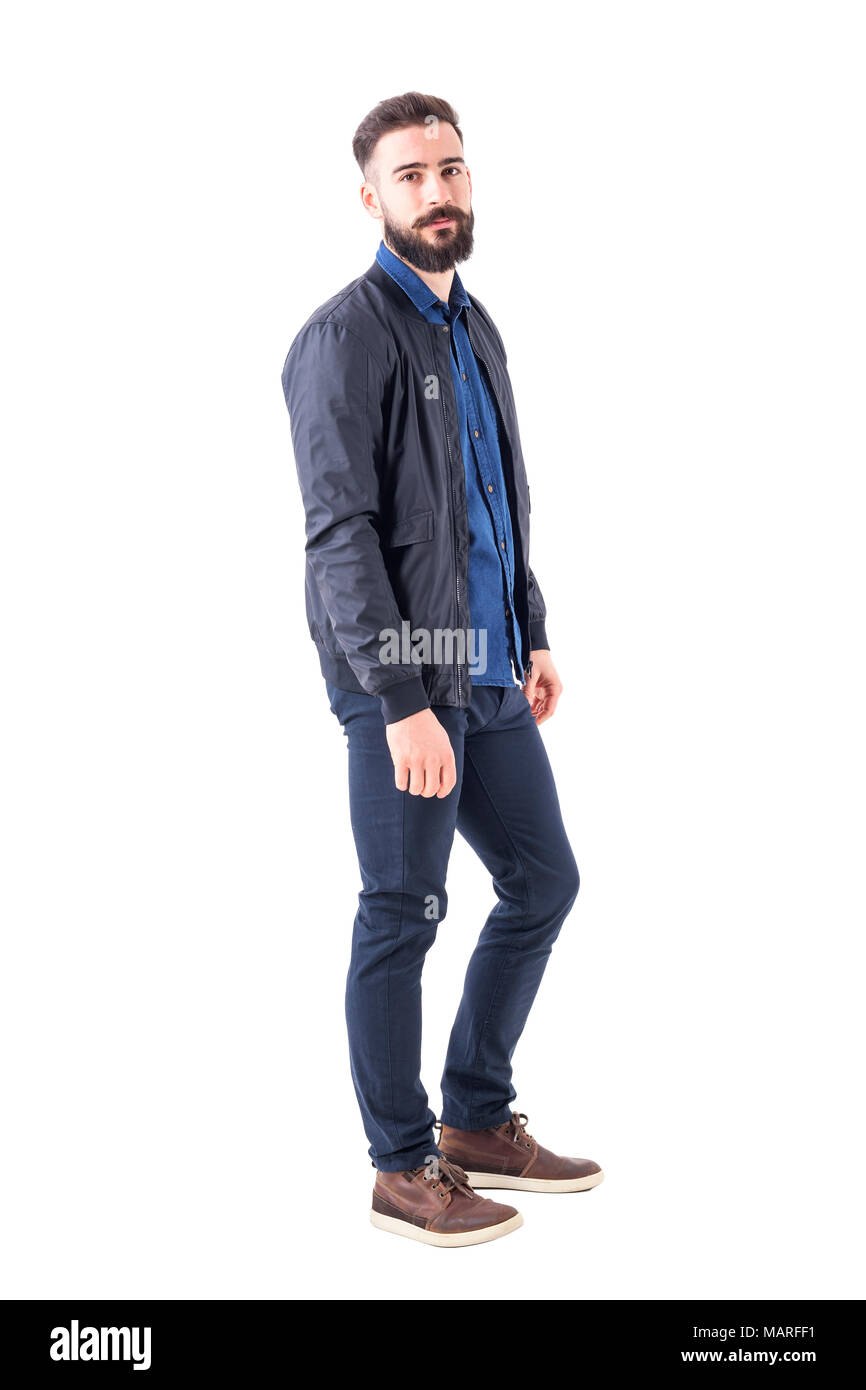 Side view of confident relaxed macho guy in bomber jacket posing and ...