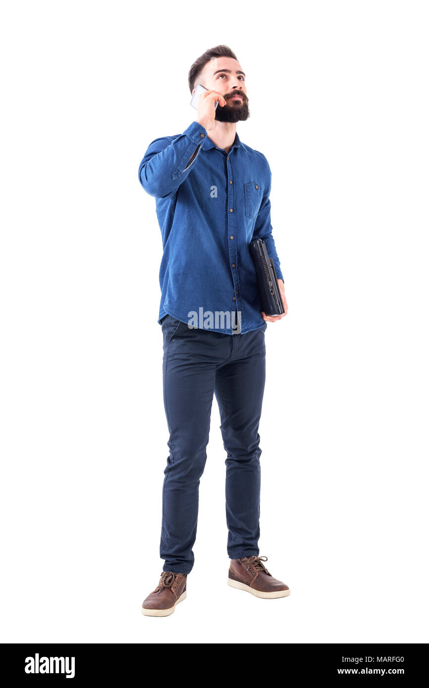 Young caucasian businessman on the phone looking up carrying laptop ...