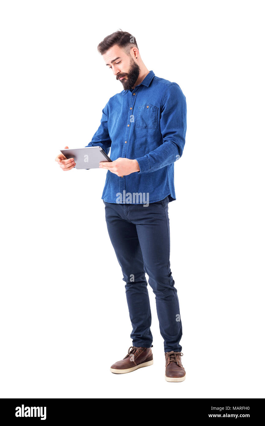 Uncertain confused business man holding and looking at tablet touch pad ...