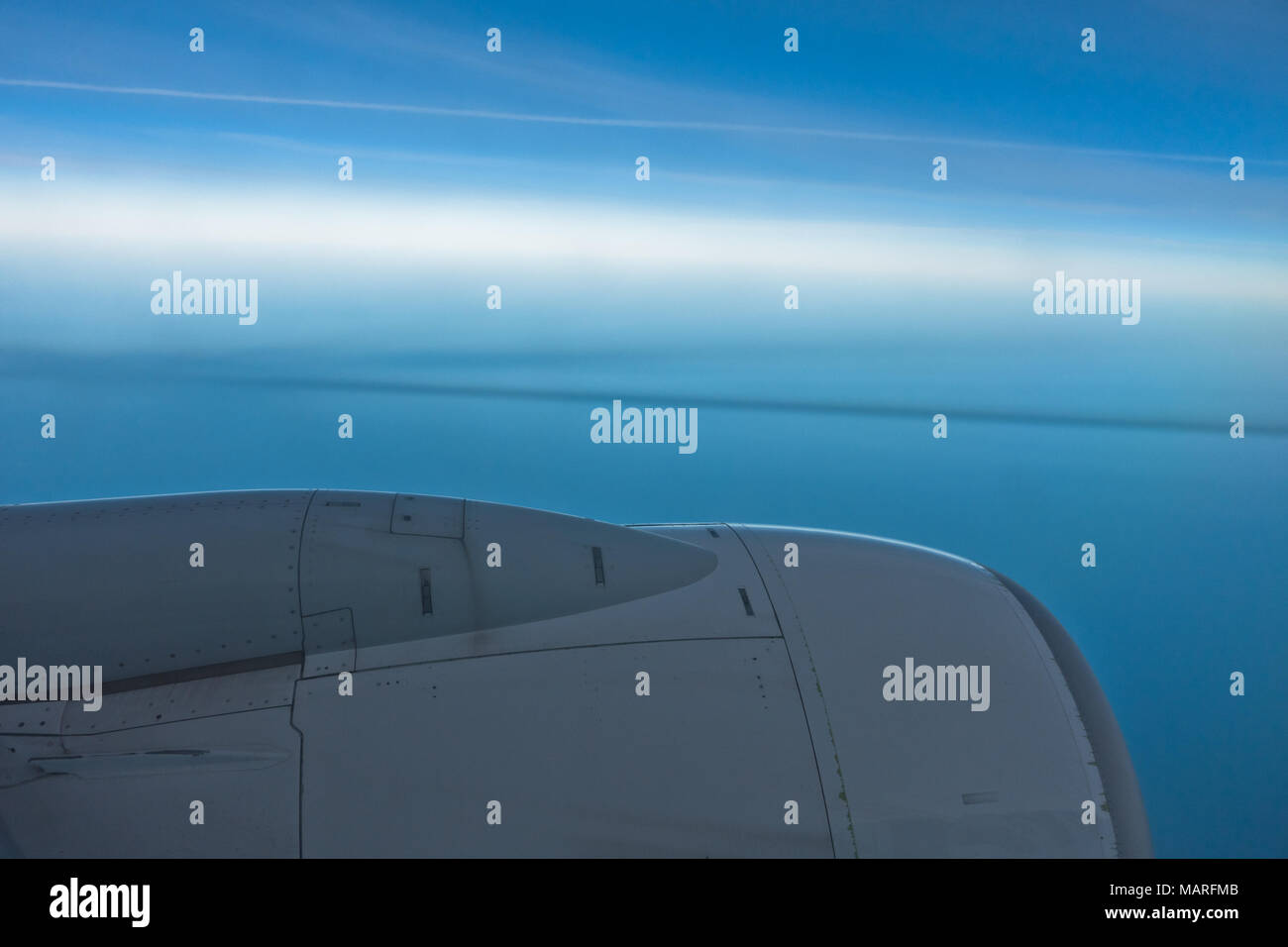 Airplane engine with clear blue sky horizon in background during flight ...