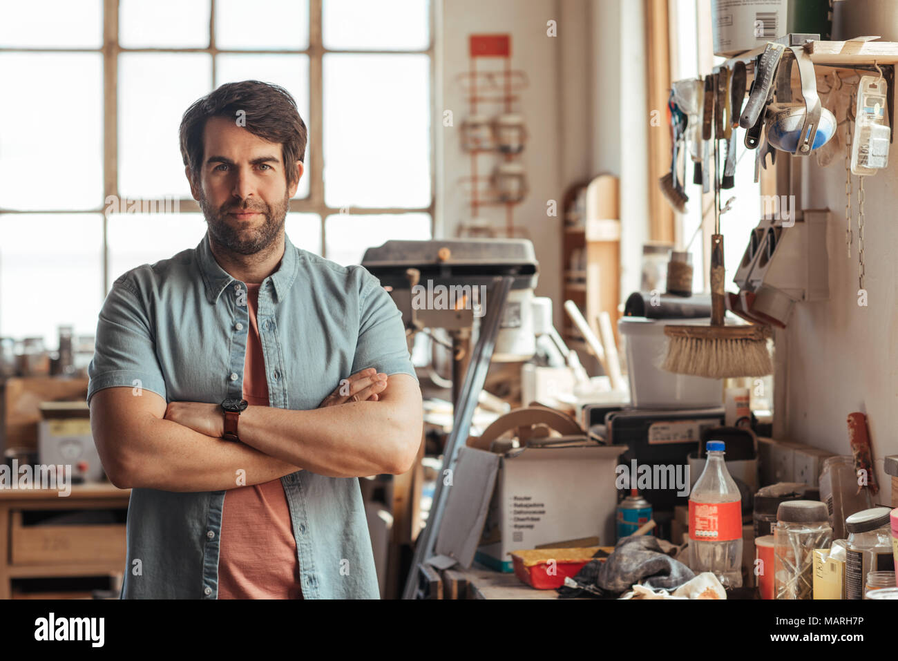 Confident young woodworker standing by a bench in his workshop Stock ...