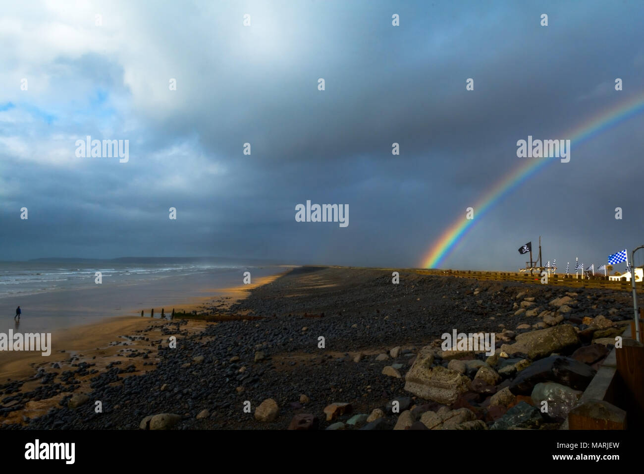 Rainbow over the beach on an overcast rainy day Stock Photo - Alamy