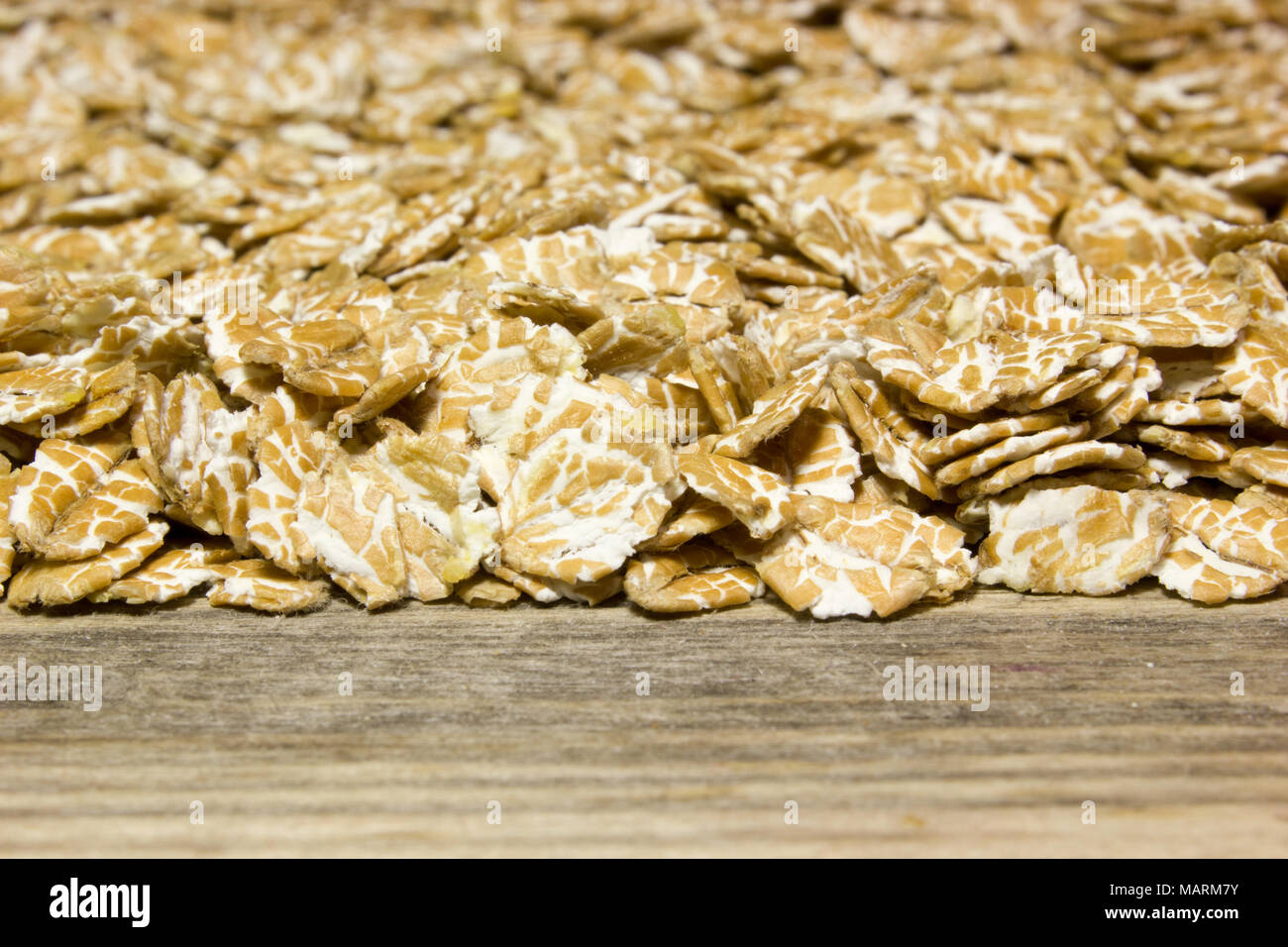 Wheat flakes on wooden background Stock Photo - Alamy