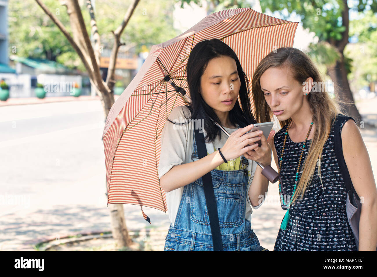 Two friends are traveling by studying the map in the navigator Stock ...