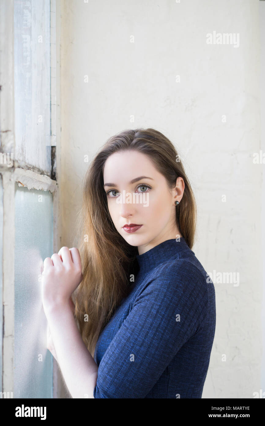 Girl standing against window hands hi-res stock photography and images ...