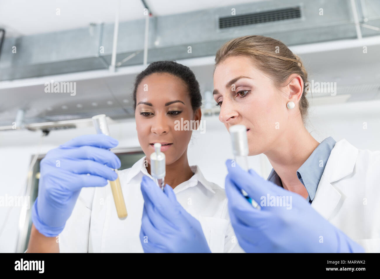 Scientists in research lab with analyzing instrument Stock Photo - Alamy