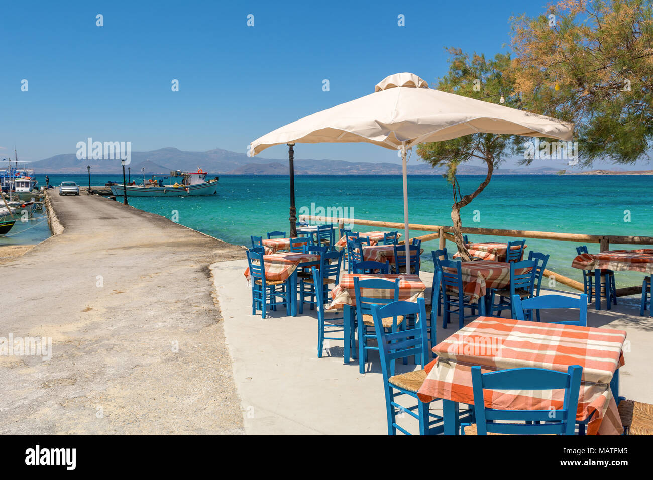 Tables with chairs in typical Greek tavern with view on sea bay. Agia ...