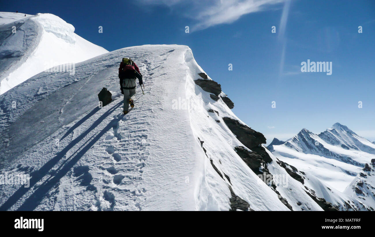 mountain guide and client on a steep north face slope heading towards ...