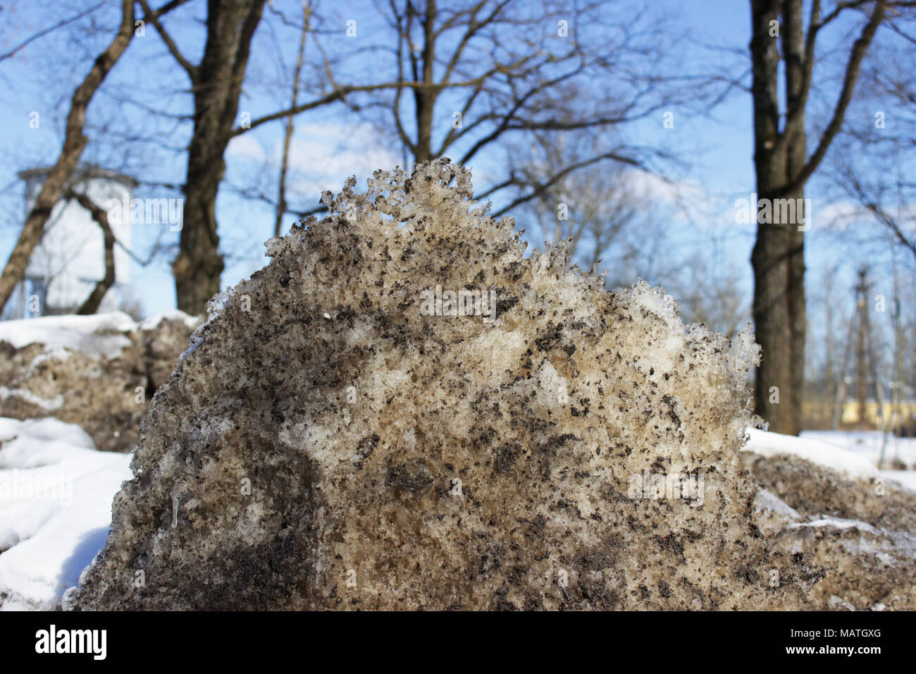 melting dirty snow piled up by a bunch after cleaning the road. Spring ...