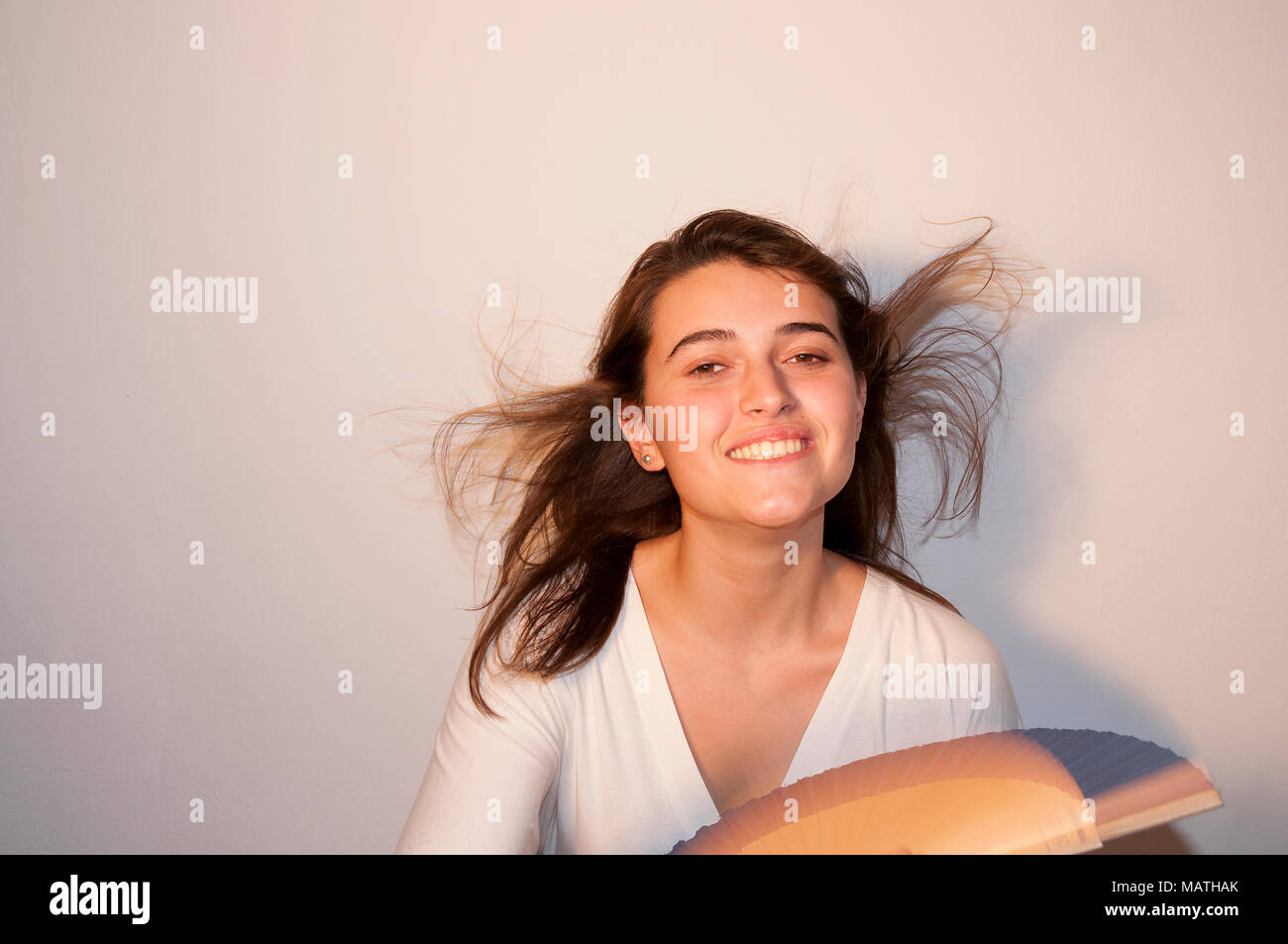 Young woman laughing and fanning herself Stock Photo - Alamy