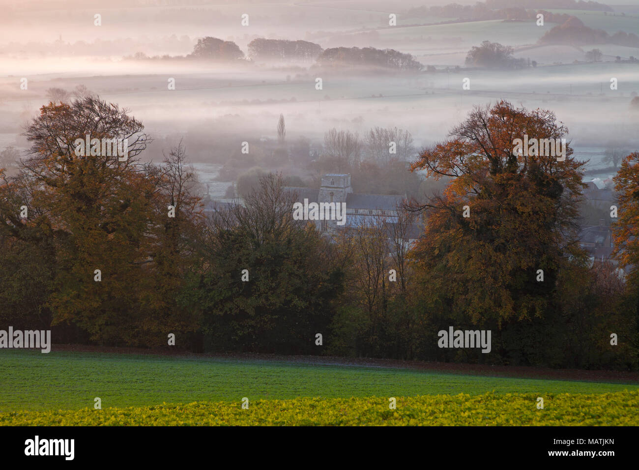 The village of Heytesbury in Wiltshire viewed through layers of mist ...