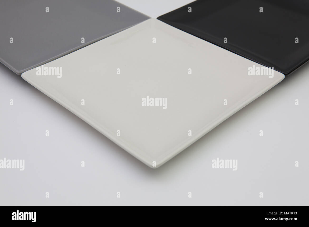 Black, white and gray square plates for sushi on the white table Stock ...