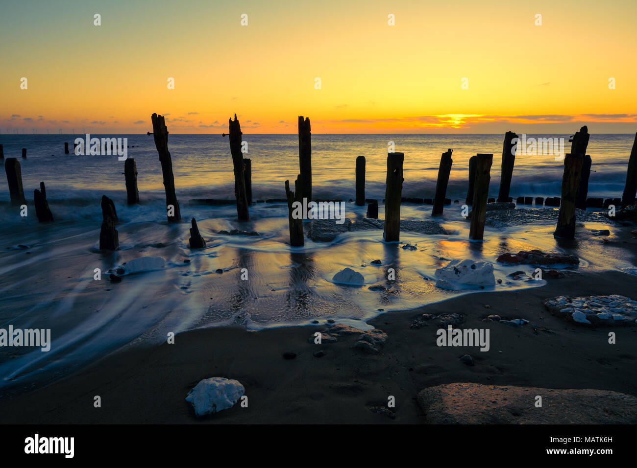 Sunrise over beach at Spurn Point Nature Reserve as tide washes around ...
