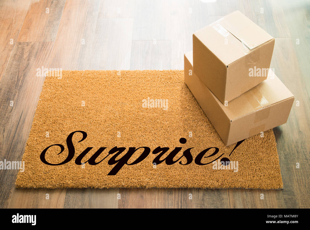 Surprise Welcome Mat On Wood Floor With Shipment of Boxes Stock Photo ...