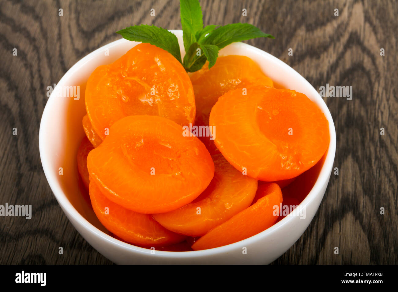 Canned apricots with mint leaves Stock Photo - Alamy