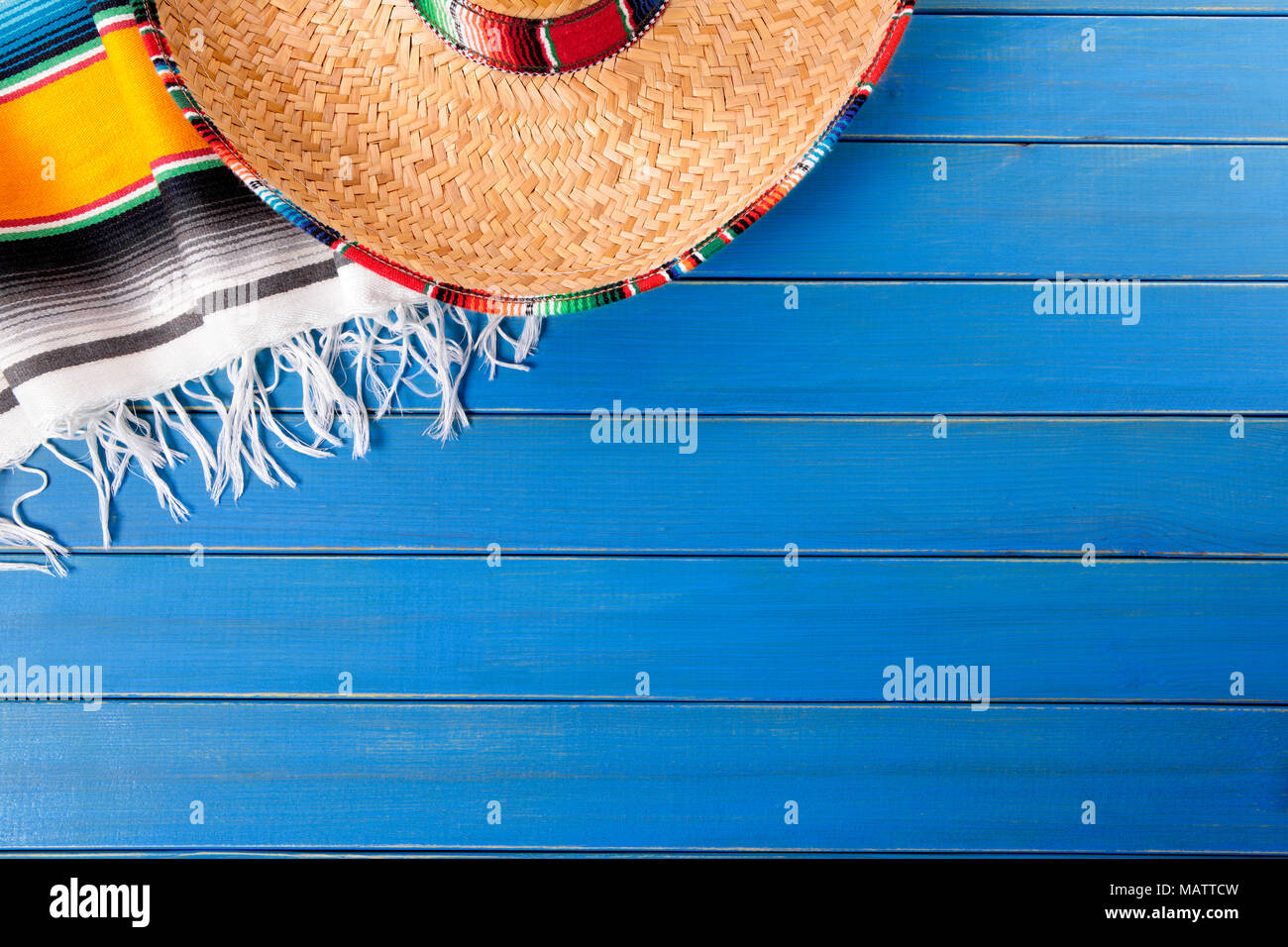 Mexican sombrero and traditional serape blanket laid on an old blue ...