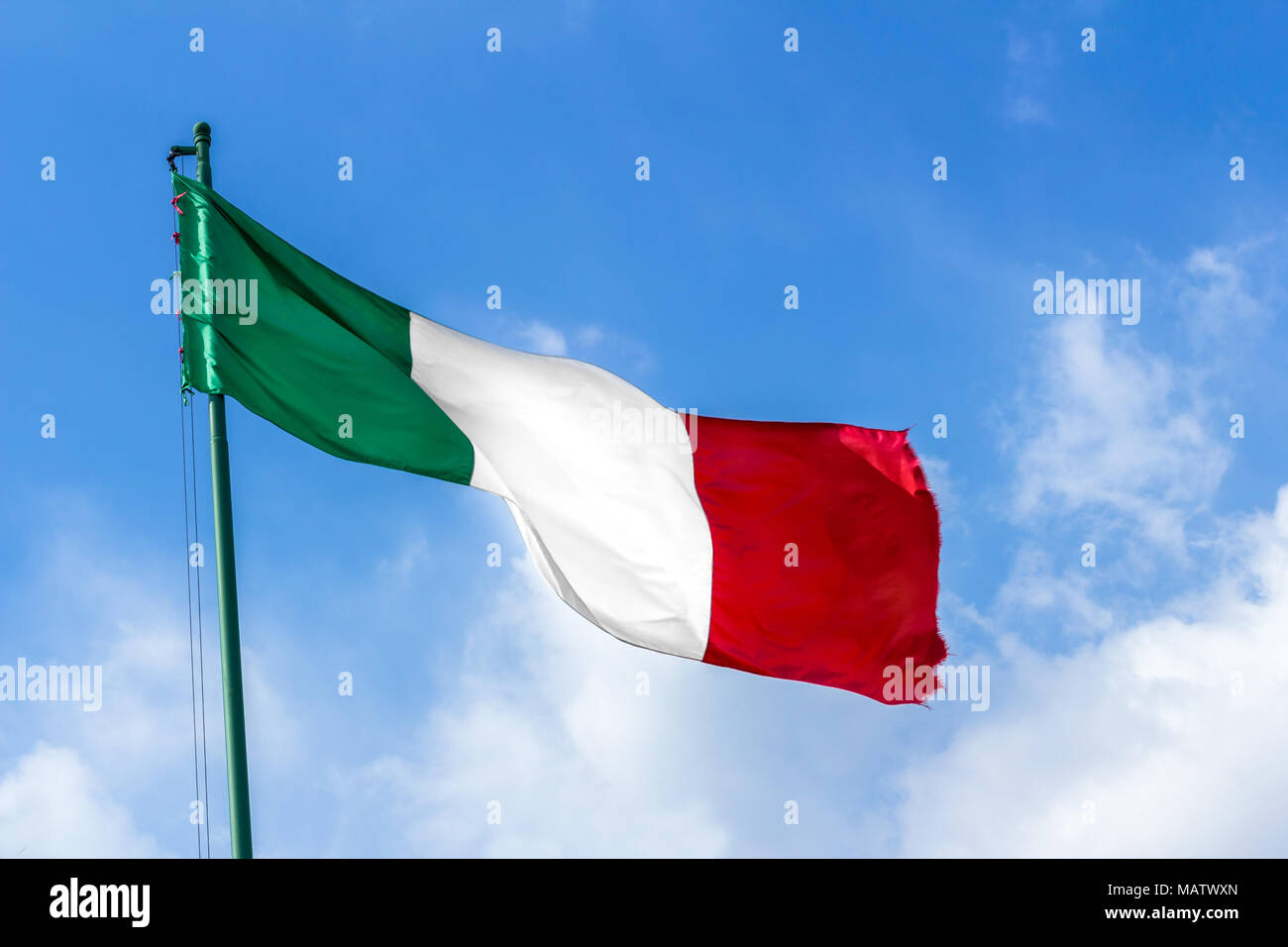 Italian flag fluttering against a bright blue sky Stock Photo - Alamy
