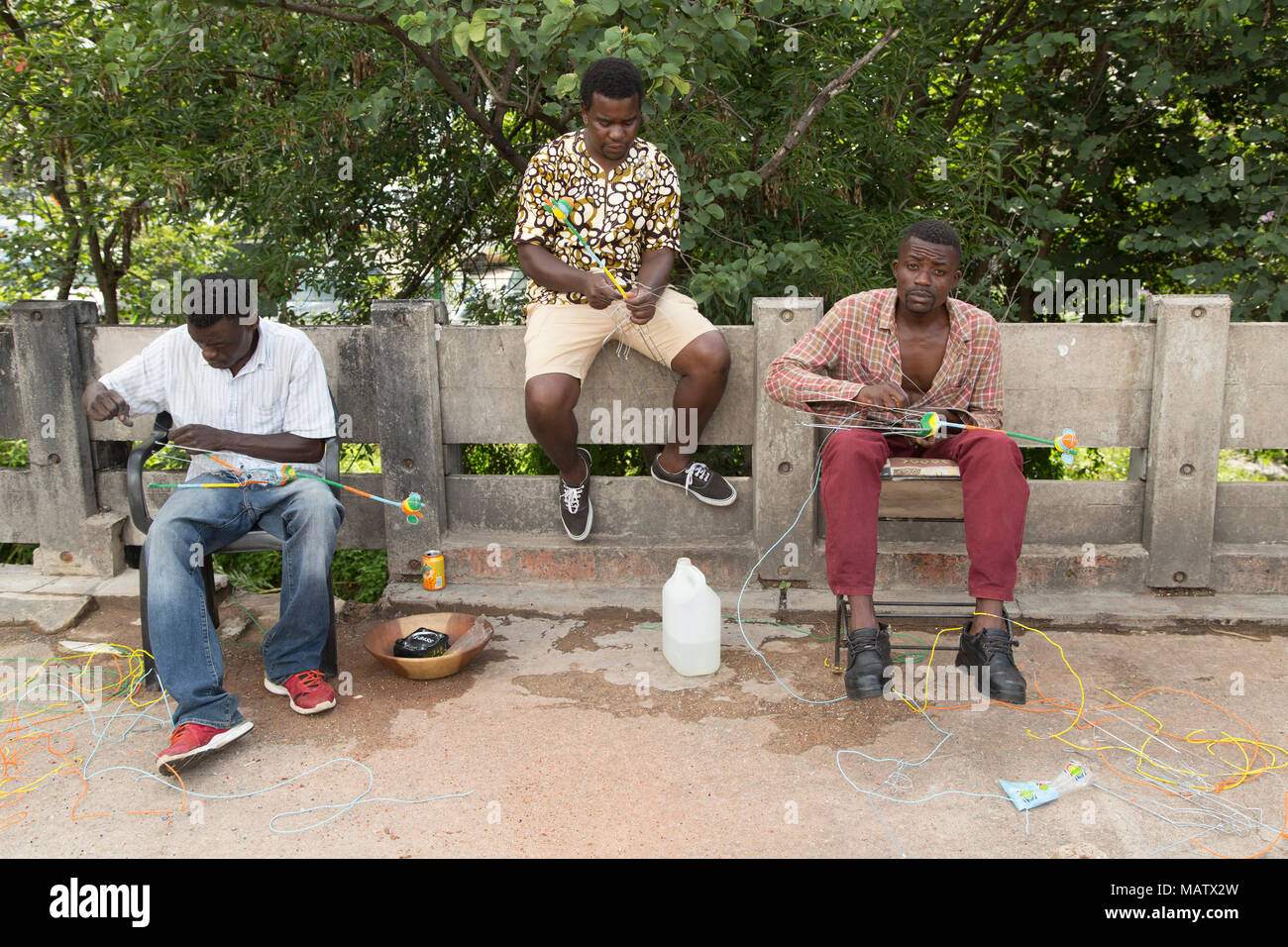 Men craft beadwork souvenirs in Harare, Zimbabwe. The men ply their ...