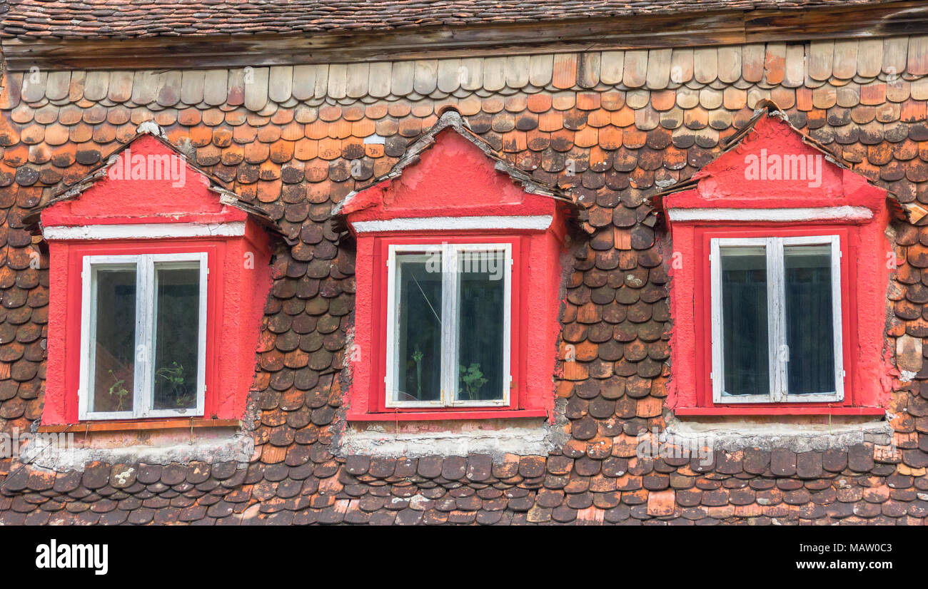 Colorful windows and roof tiles on a house in Sighisoara, Romania Stock ...