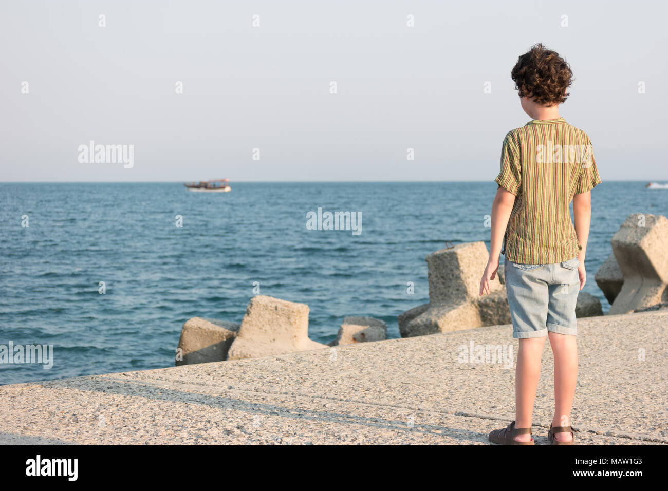 Boy standing on pier by lake hi-res stock photography and images - Alamy
