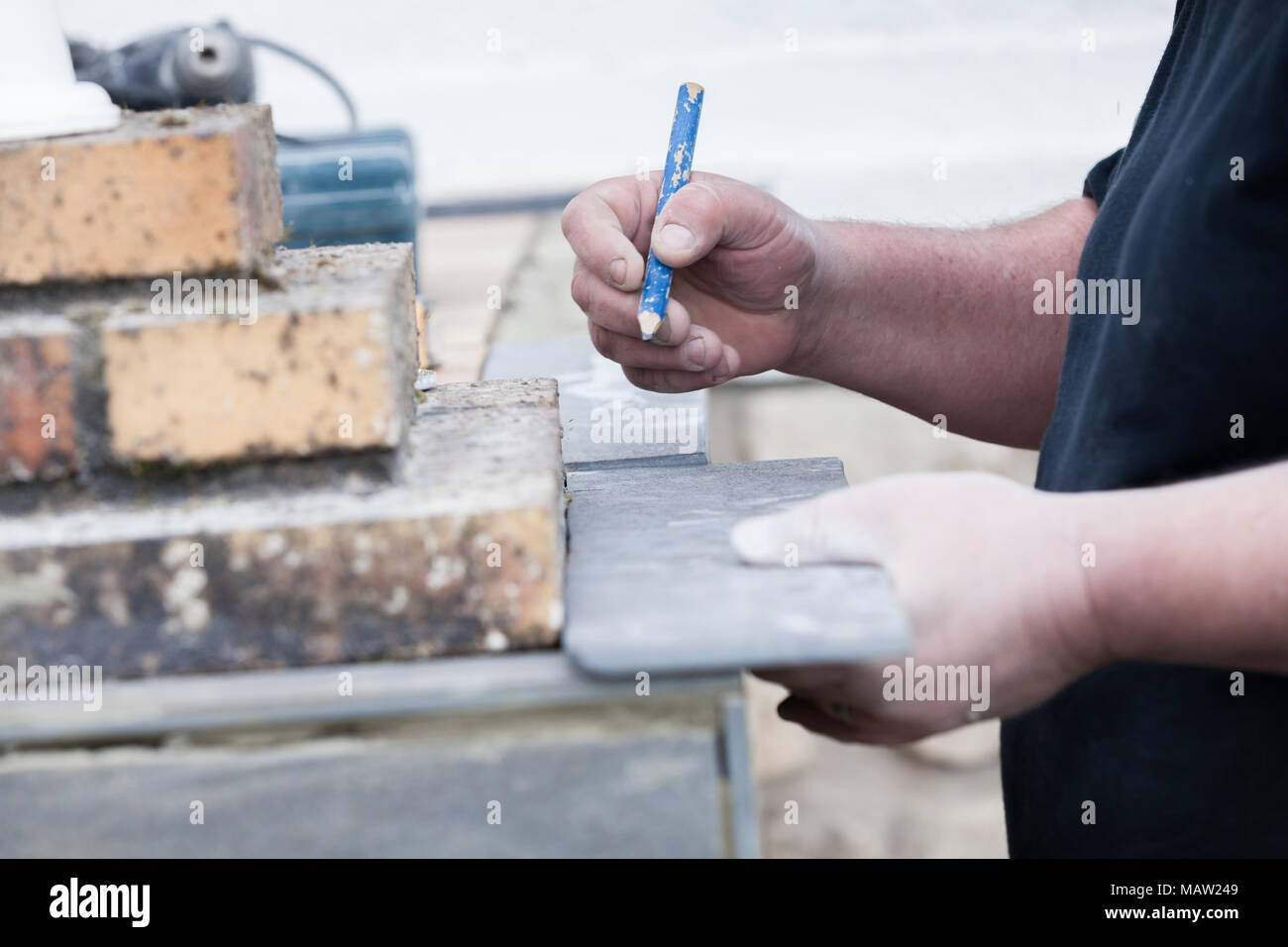 the tiler measures and puts marks to cut and lay a tile Stock Photo - Alamy